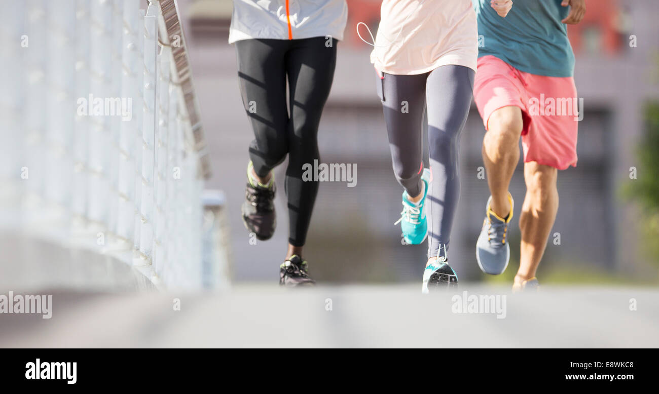 Friends running through city streets Stock Photo - Alamy