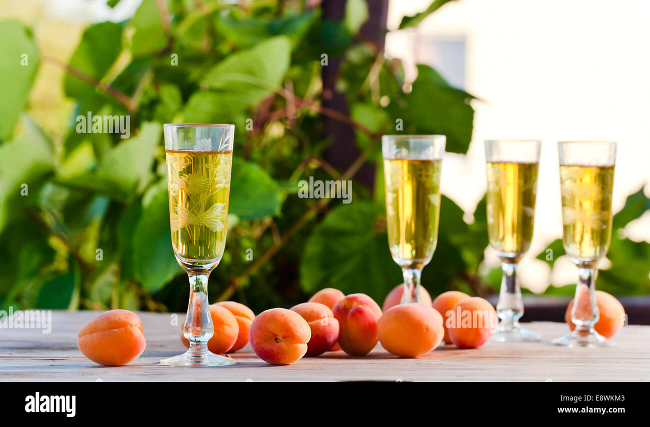 Apricot liquor and fruits on wooden table Stock Photo - Alamy