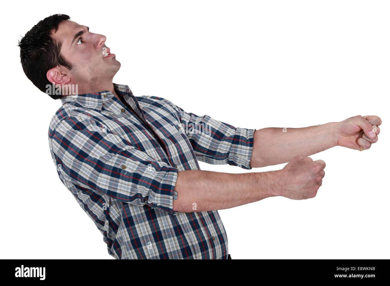 Exhausted man pulling an invisible object Stock Photo - Alamy