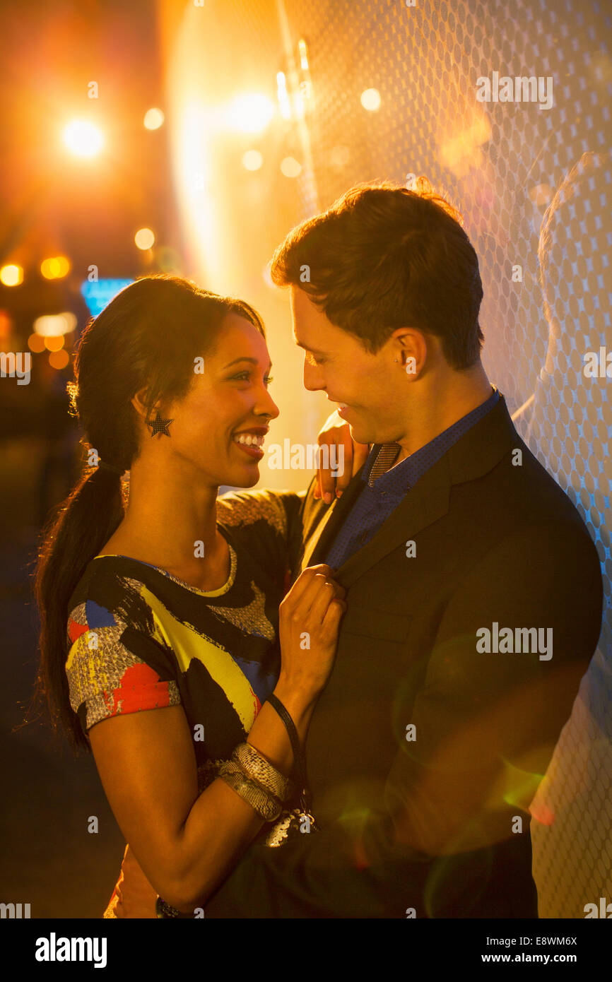 Couple hugging on city street at night Stock Photo - Alamy