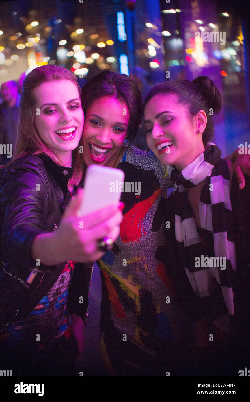 Women talking picture together using cell phone at night Stock Photo ...