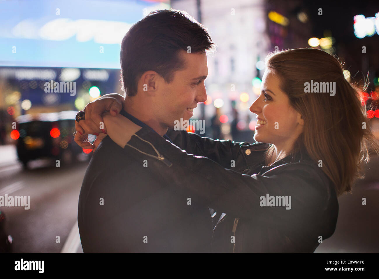 Couple hugging on city street at night Stock Photo - Alamy