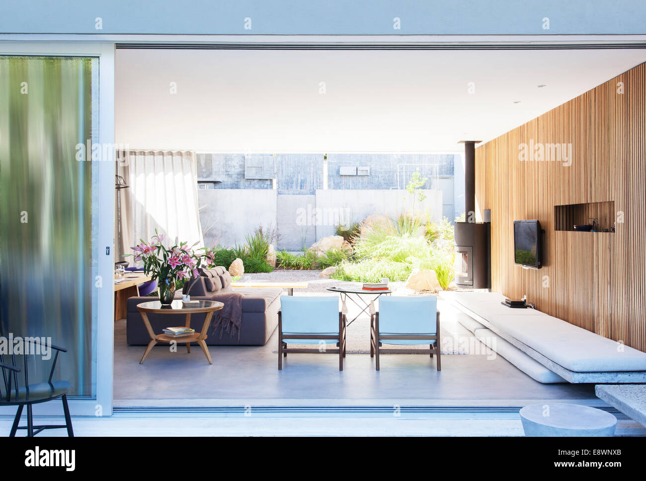 Sliding glass door opening to modern living room Stock Photo - Alamy
