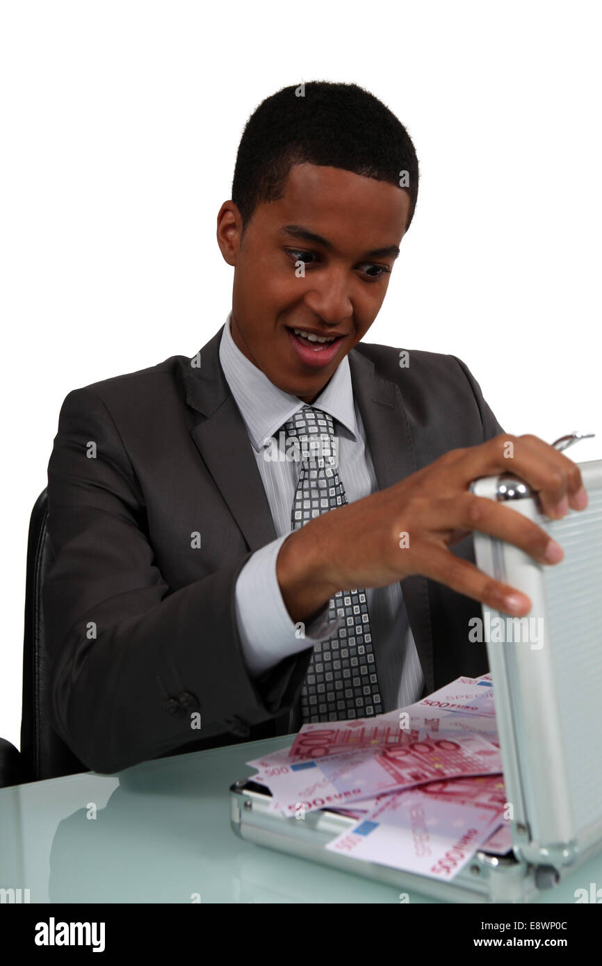 A con man opening a case full of money Stock Photo - Alamy