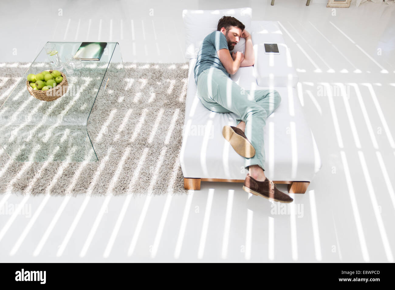 Man napping on daybed in modern living room Stock Photo - Alamy