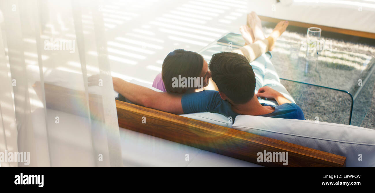 Couple relaxing together on sofa in modern living room Stock Photo - Alamy