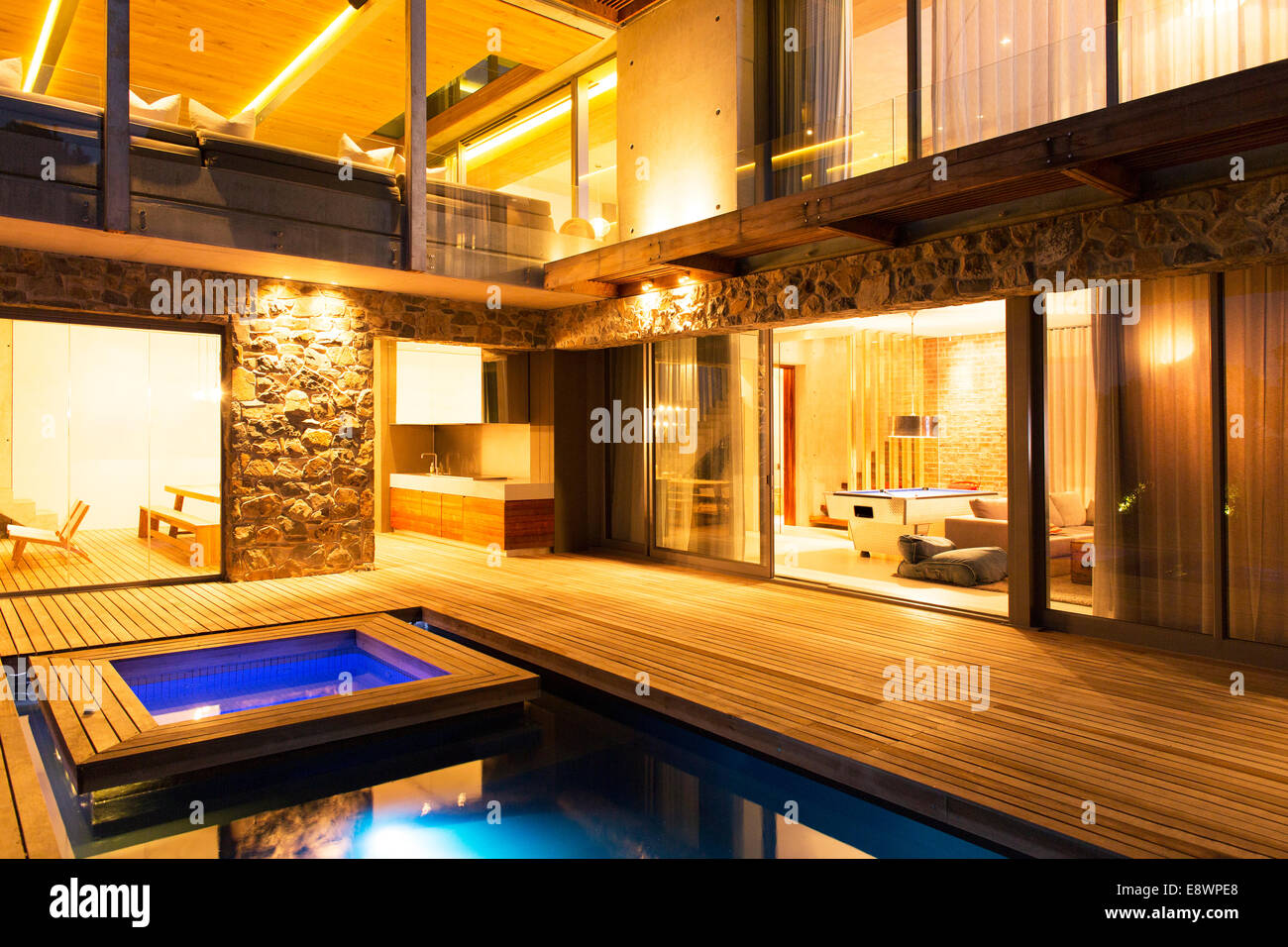 Modern house overlooking illuminated swimming pool at night Stock Photo ...