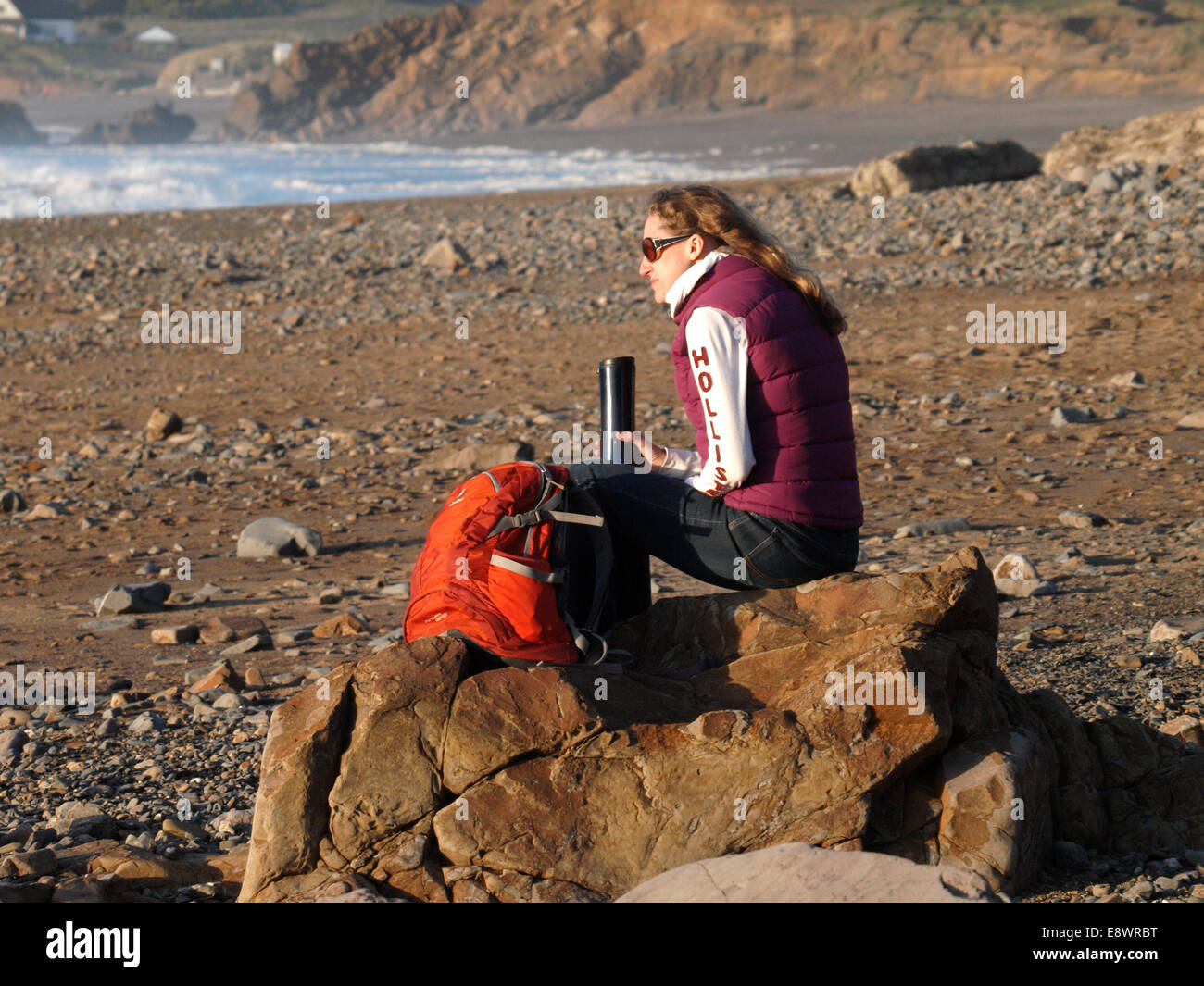 Woman sat on rock beach hi-res stock photography and images - Alamy