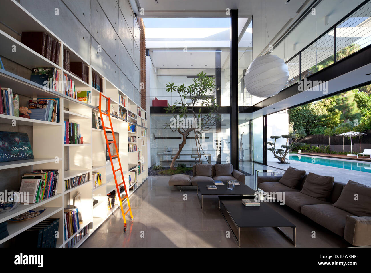 Double height living room with bookcase in Dahan House, Israel, Middle ...