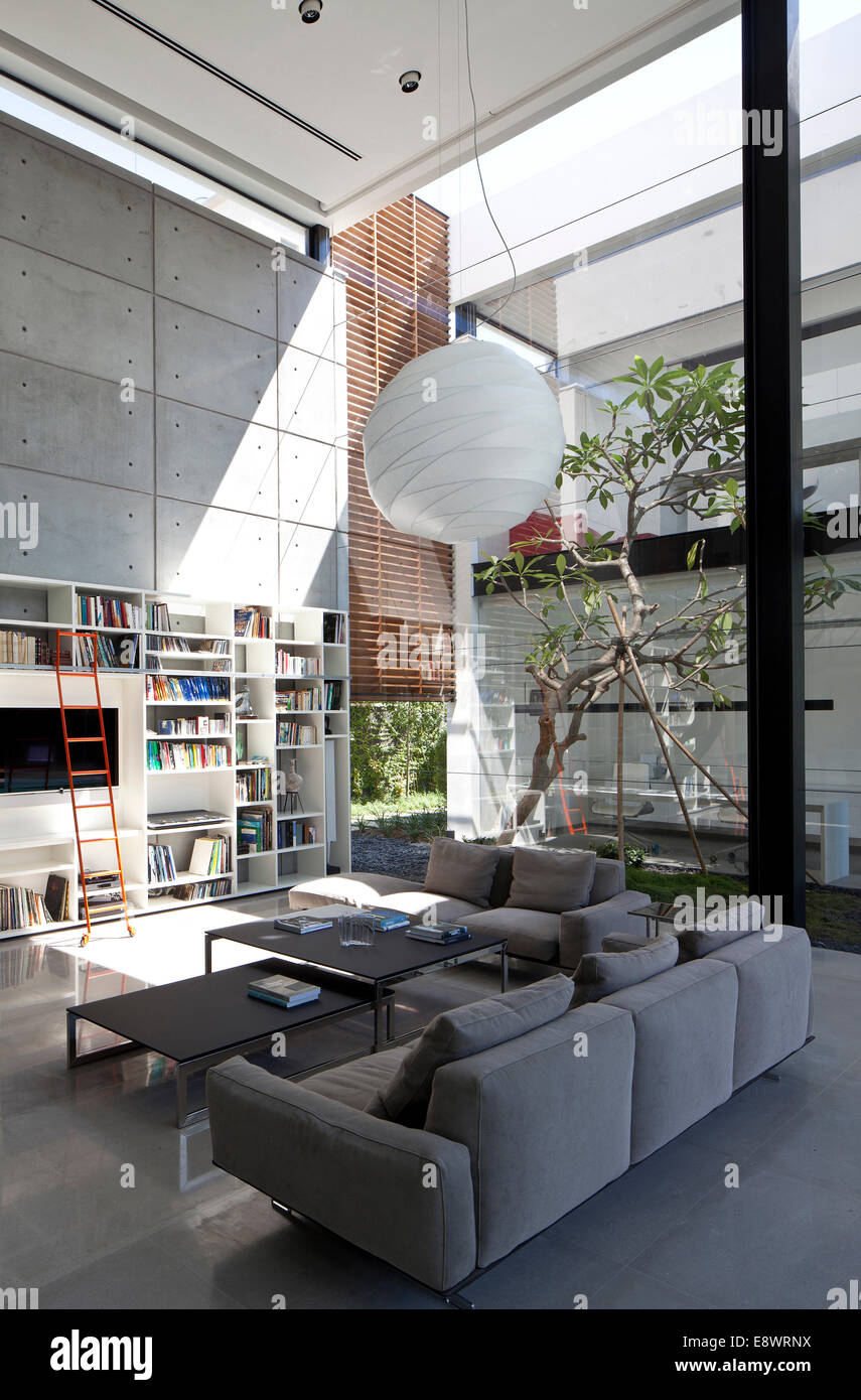 Double height living room with bookcase in Dahan House, Israel, Middle ...