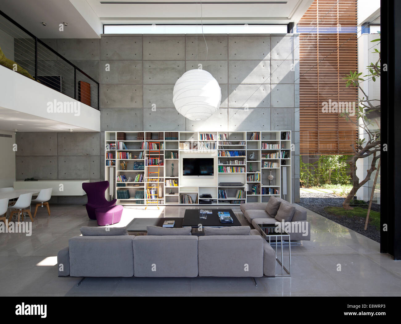 Double height living room with bookcase in Dahan House, Israel, Middle ...