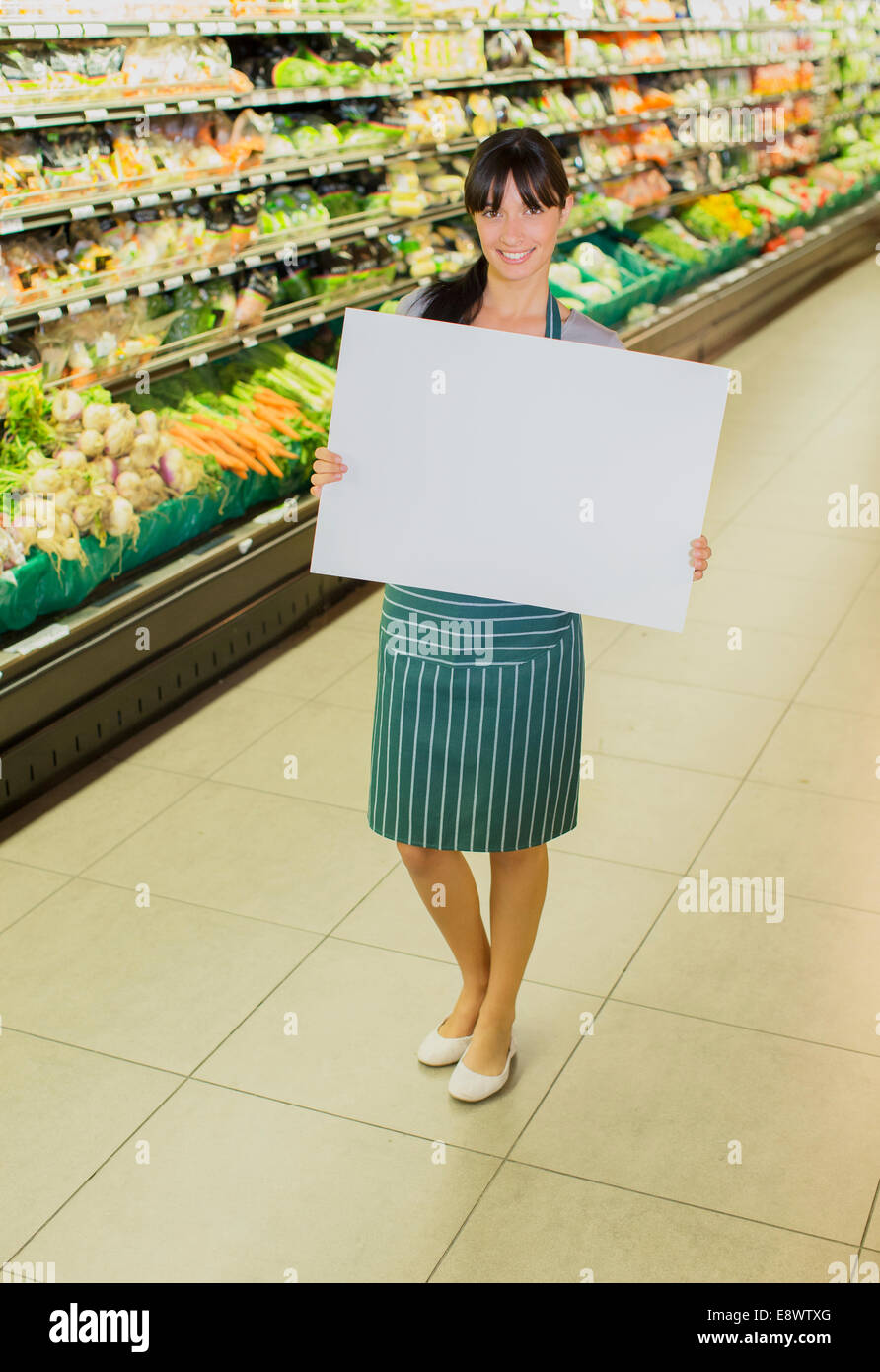 Clerk holding blank card in produce section of grocery store Stock ...