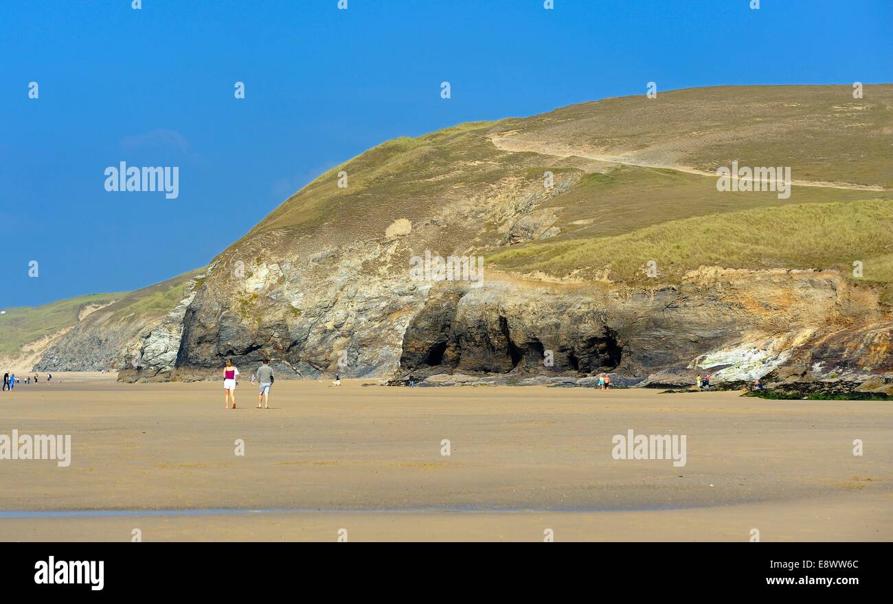 A couple walking along Penhale Sands Perranporth Beach Cornwall England ...