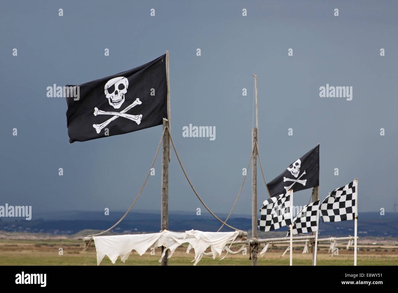 Black and white pirate flags flying high from a play ship's masts on a ...