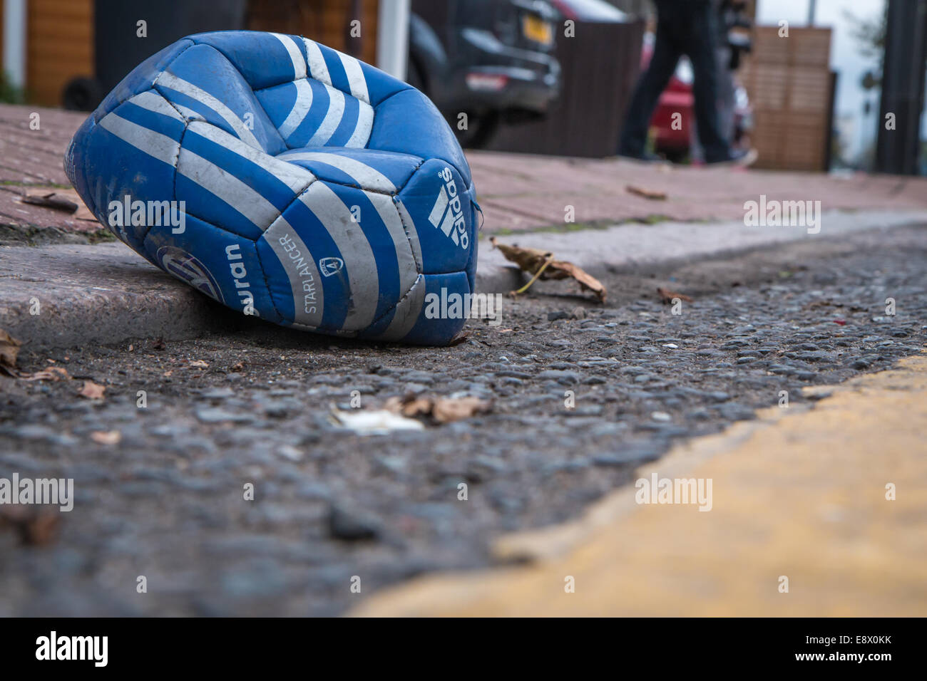 deflated football in the gutter Stock Photo - Alamy