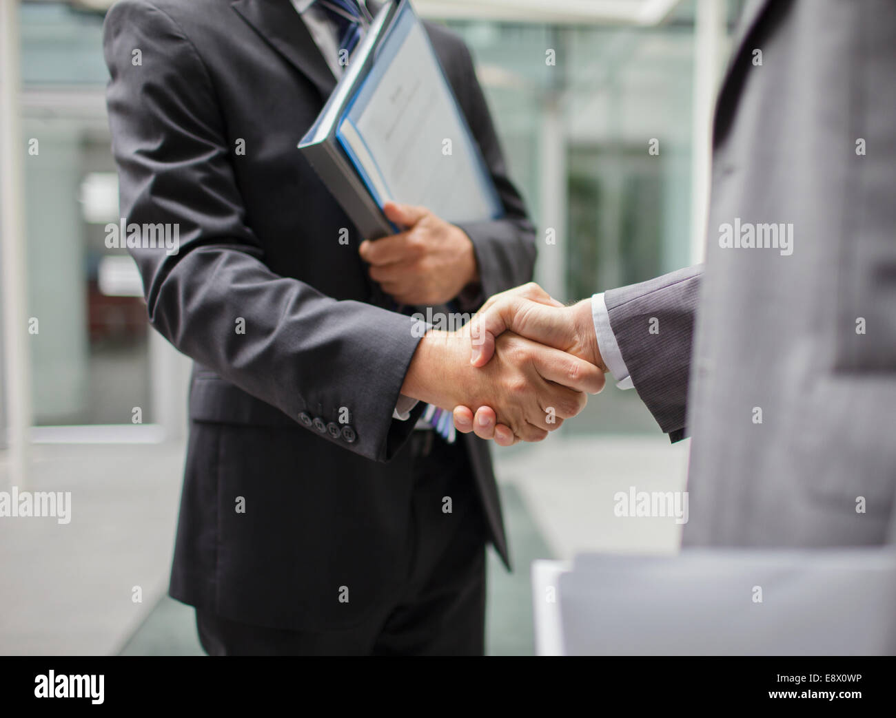 Businessmen shaking hands outdoors Stock Photo - Alamy