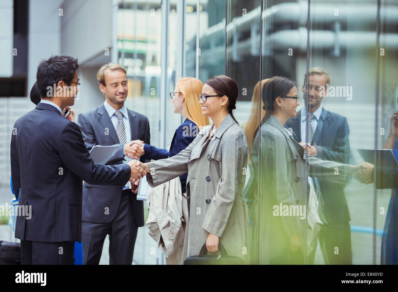 Business people shaking hands outside of office building Stock Photo ...