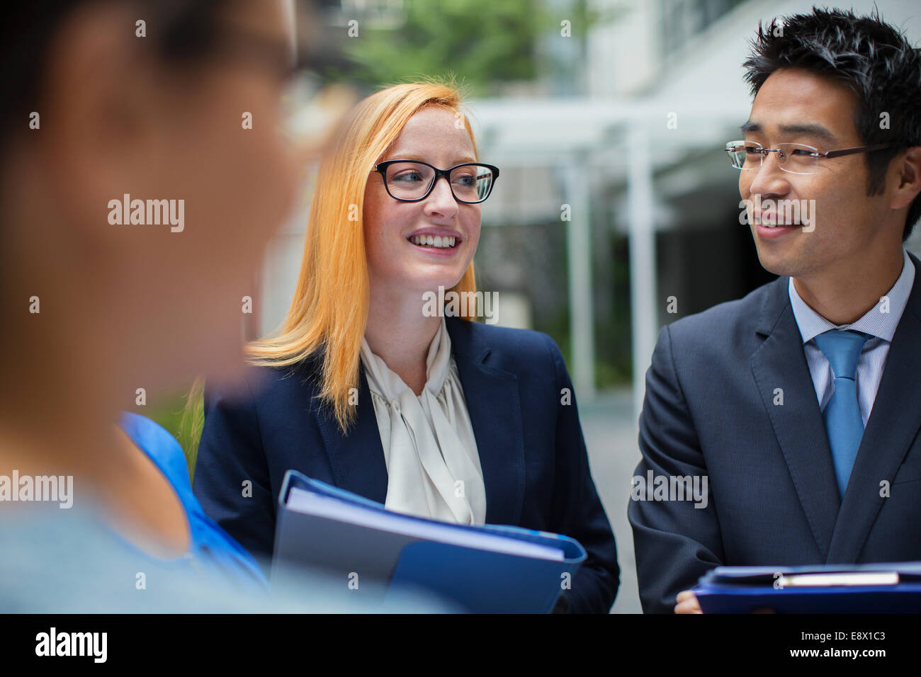 Businesspeople talking outside of office building Stock Photo - Alamy