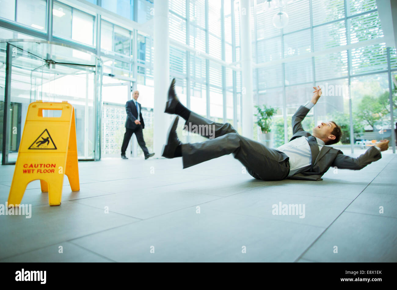 Businessman slipping on floor of office building Stock Photo - Alamy
