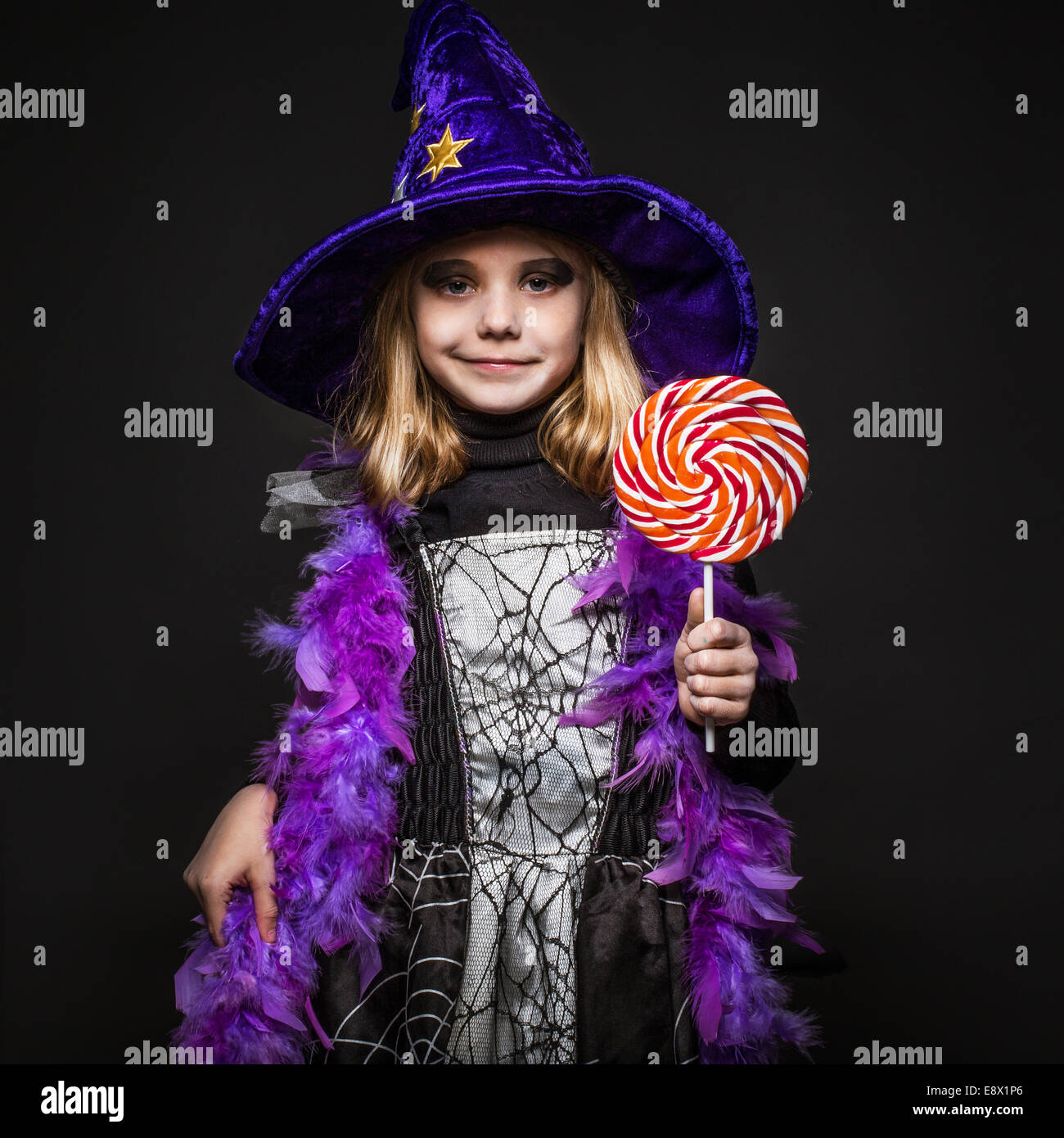 Little beautiful halloween witch with colorful candy Stock Photo - Alamy