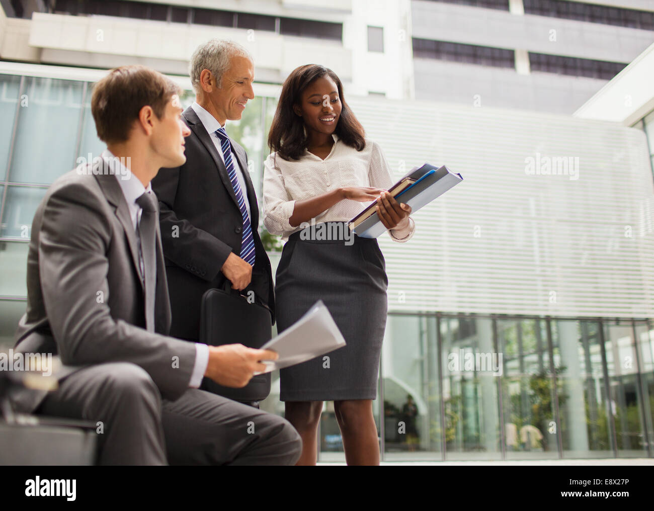 Business people looking at documents in office building Stock Photo - Alamy
