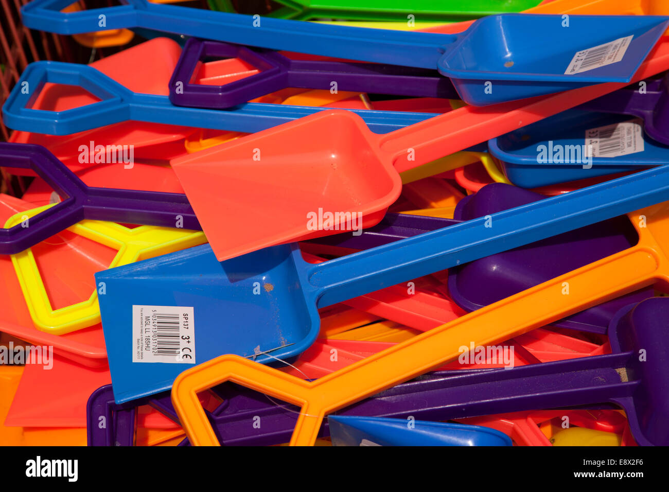 Colourful multicoloured childrens plastic spades outside a shop in ...