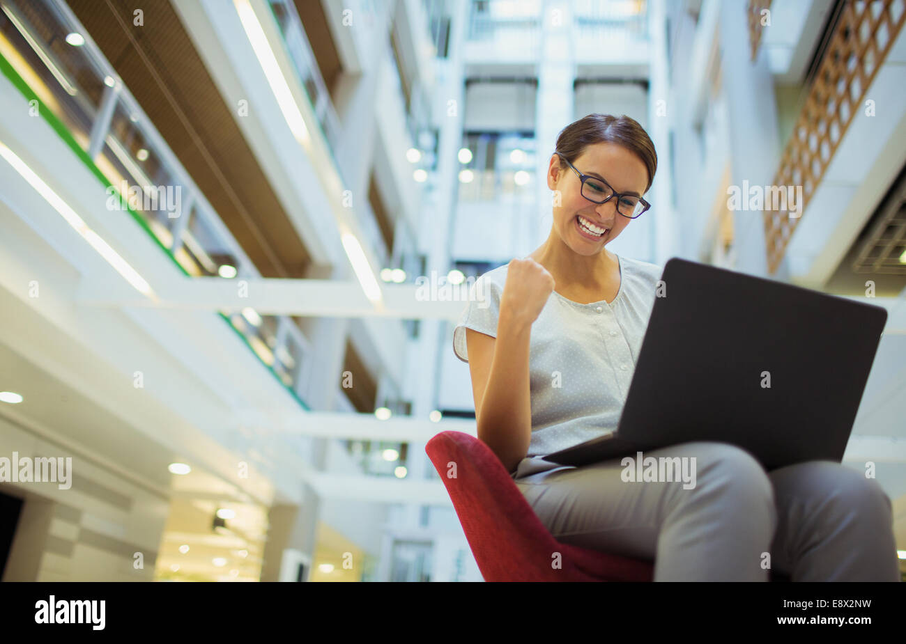 Businesswoman getting excited in office building Stock Photo - Alamy