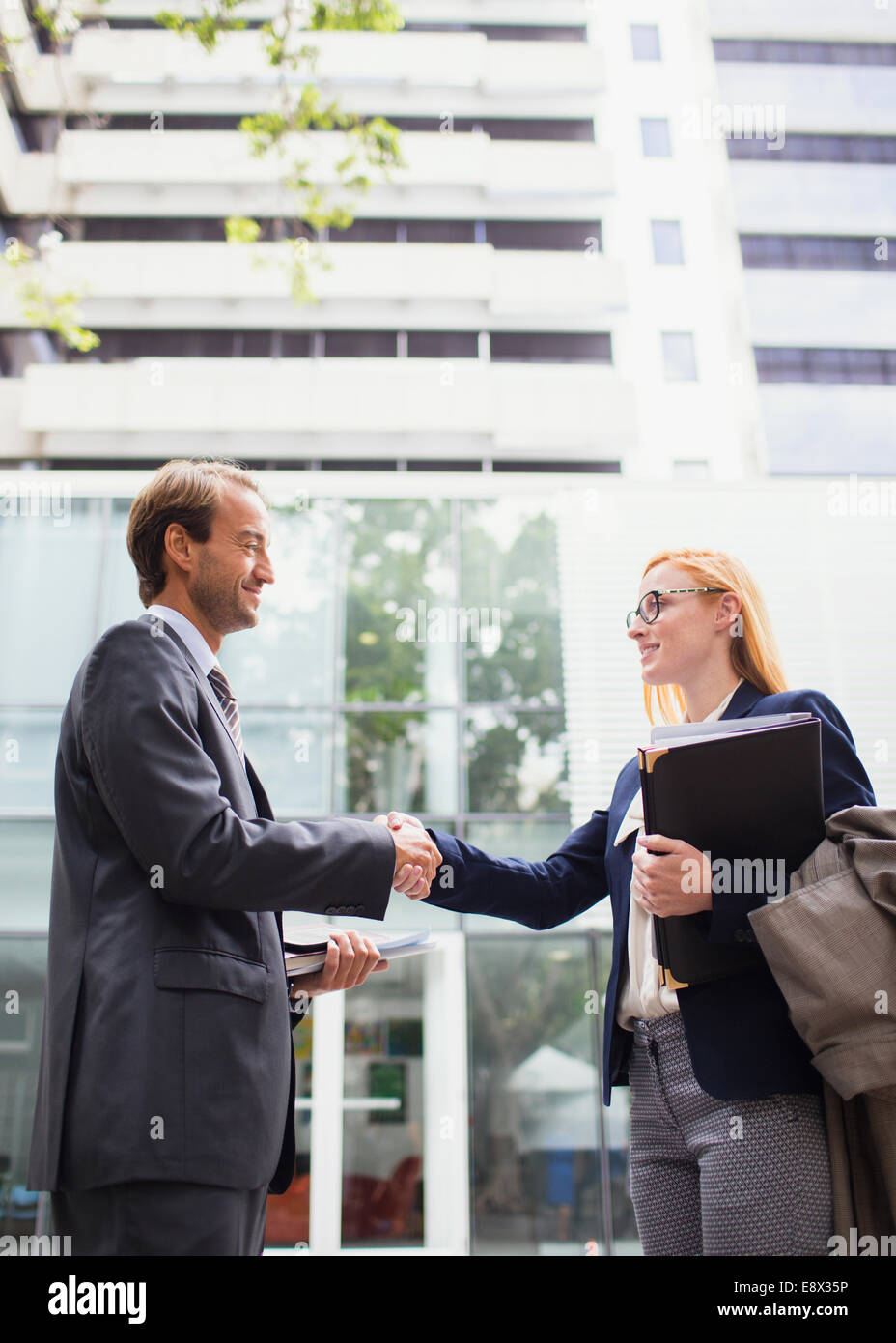 Business people shaking hands outside of office building Stock Photo ...