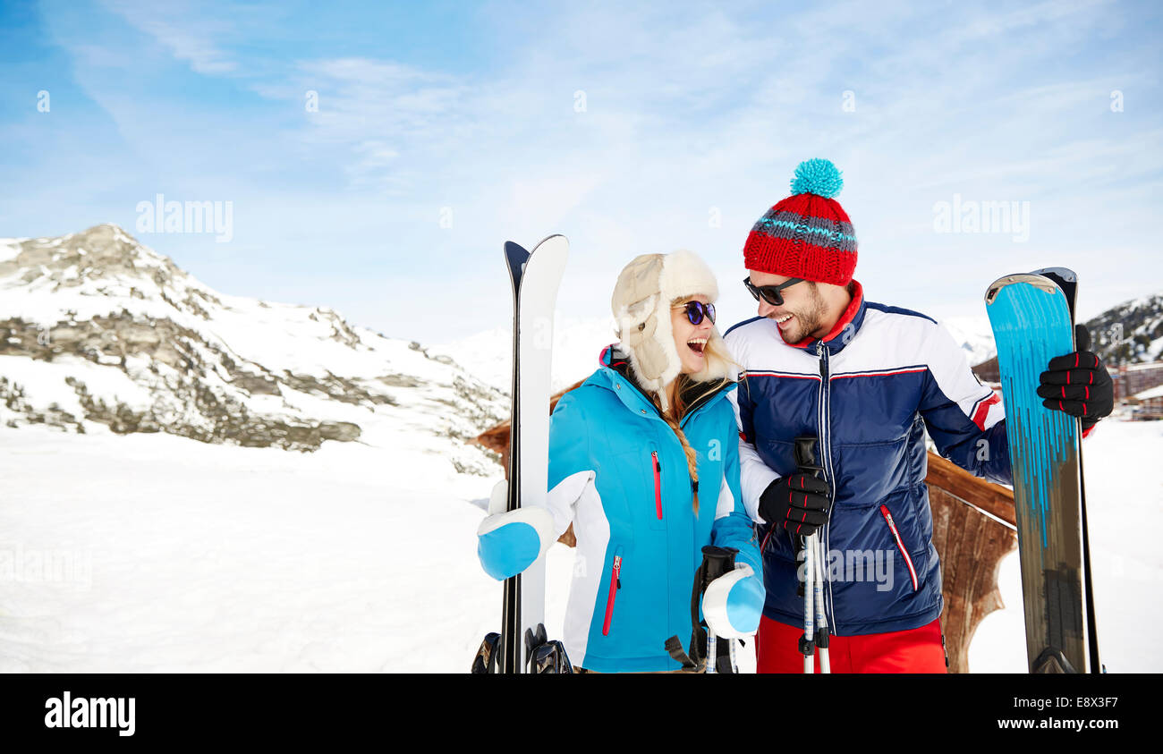 Couple holding skis together Stock Photo - Alamy