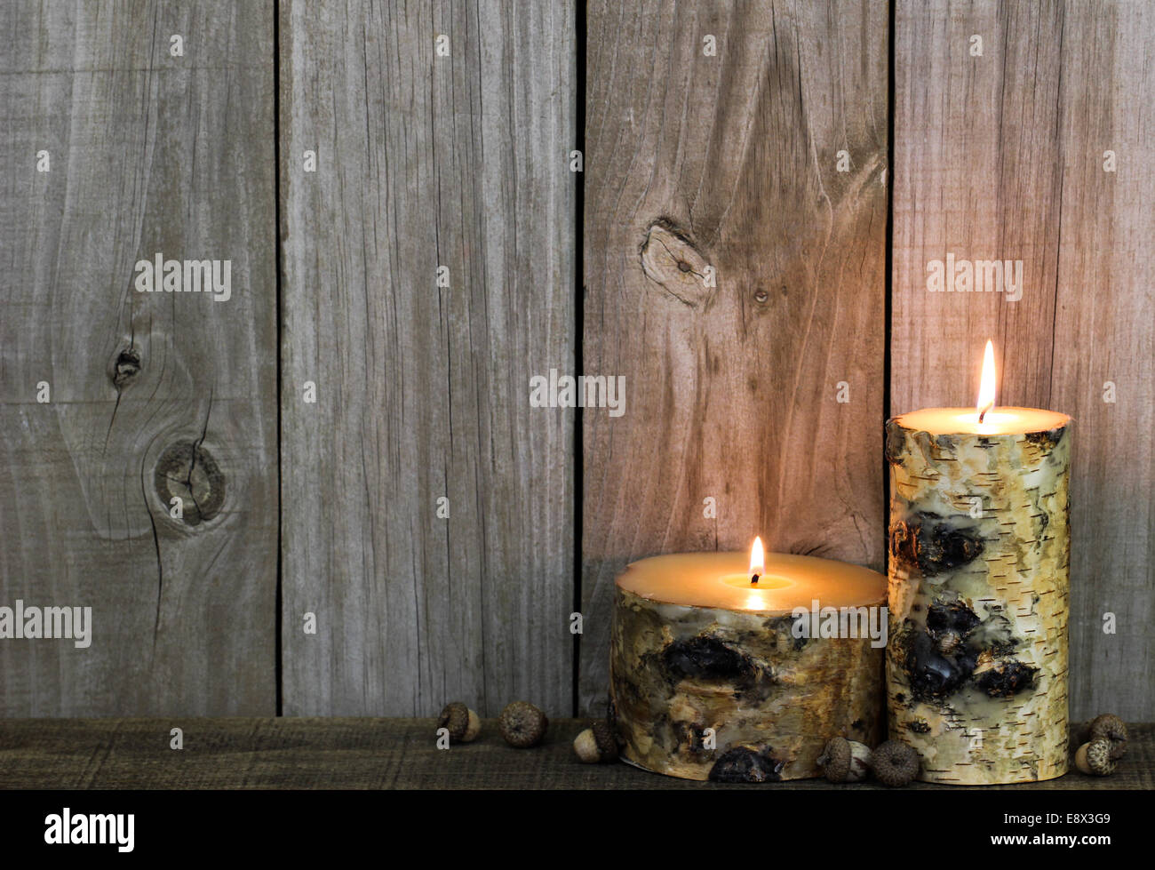Log candles burning next to antique old weathered country wooden ...