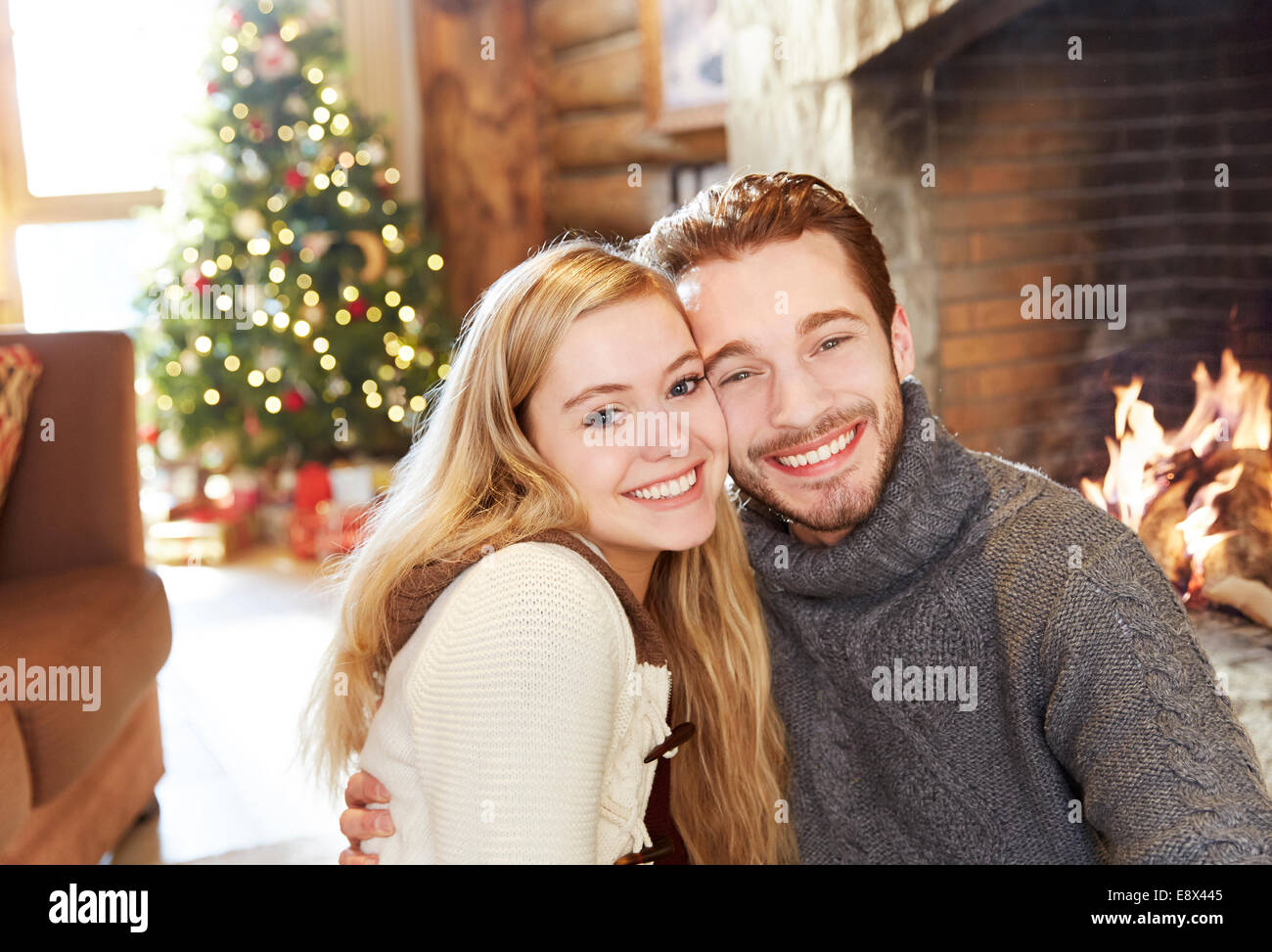 Couple hugging in front of fireplace Stock Photo - Alamy