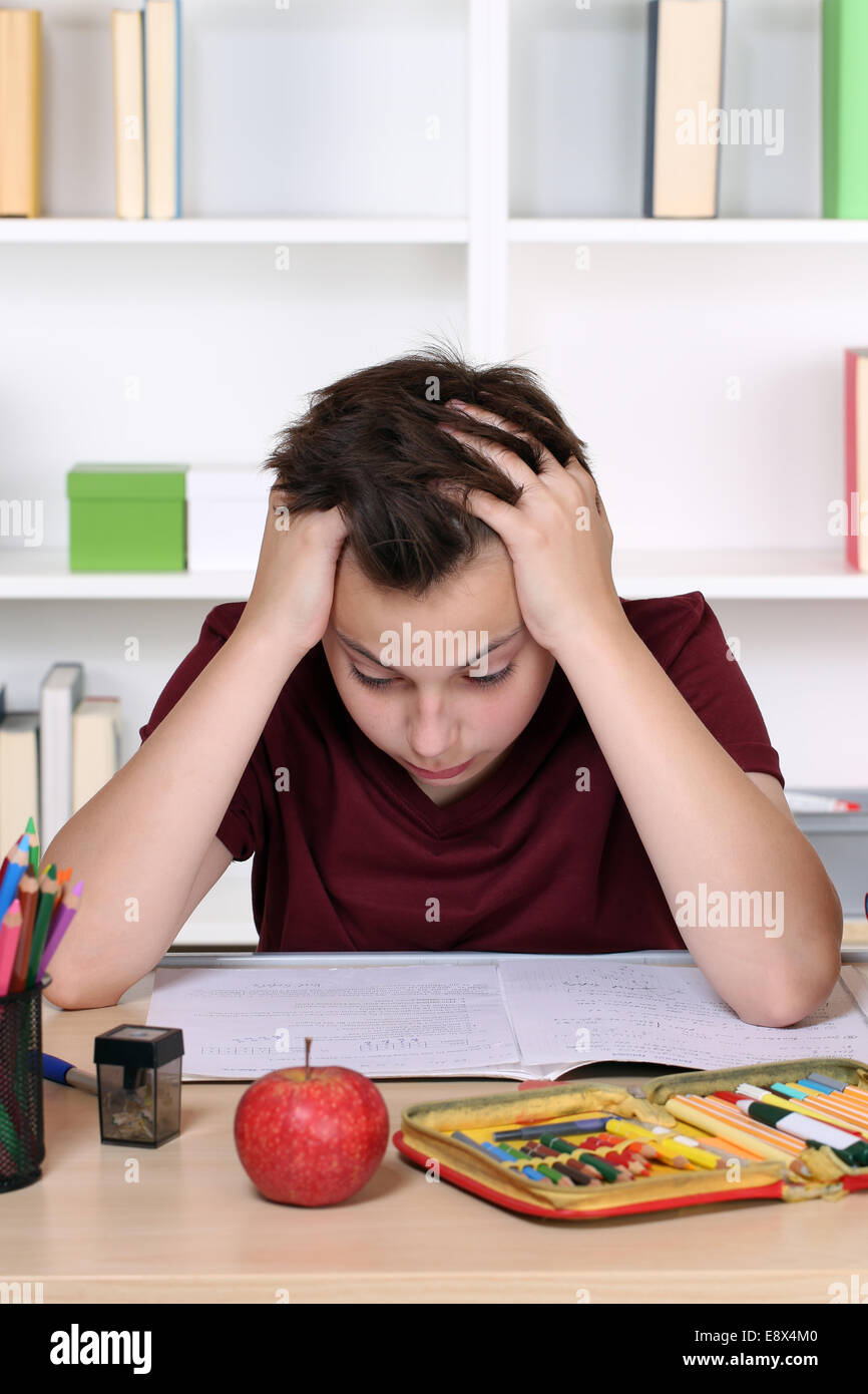 Young student is desperate and overworked with his homework at school ...