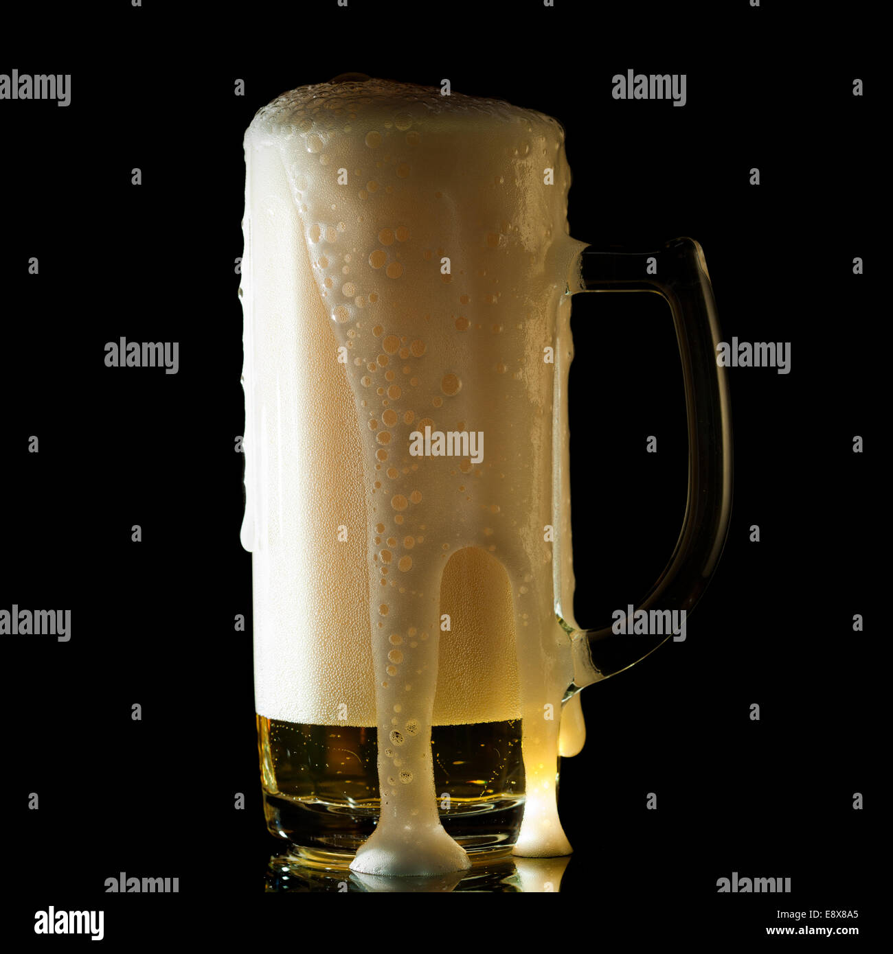 overflowing beer mug isolated on black Stock Photo - Alamy