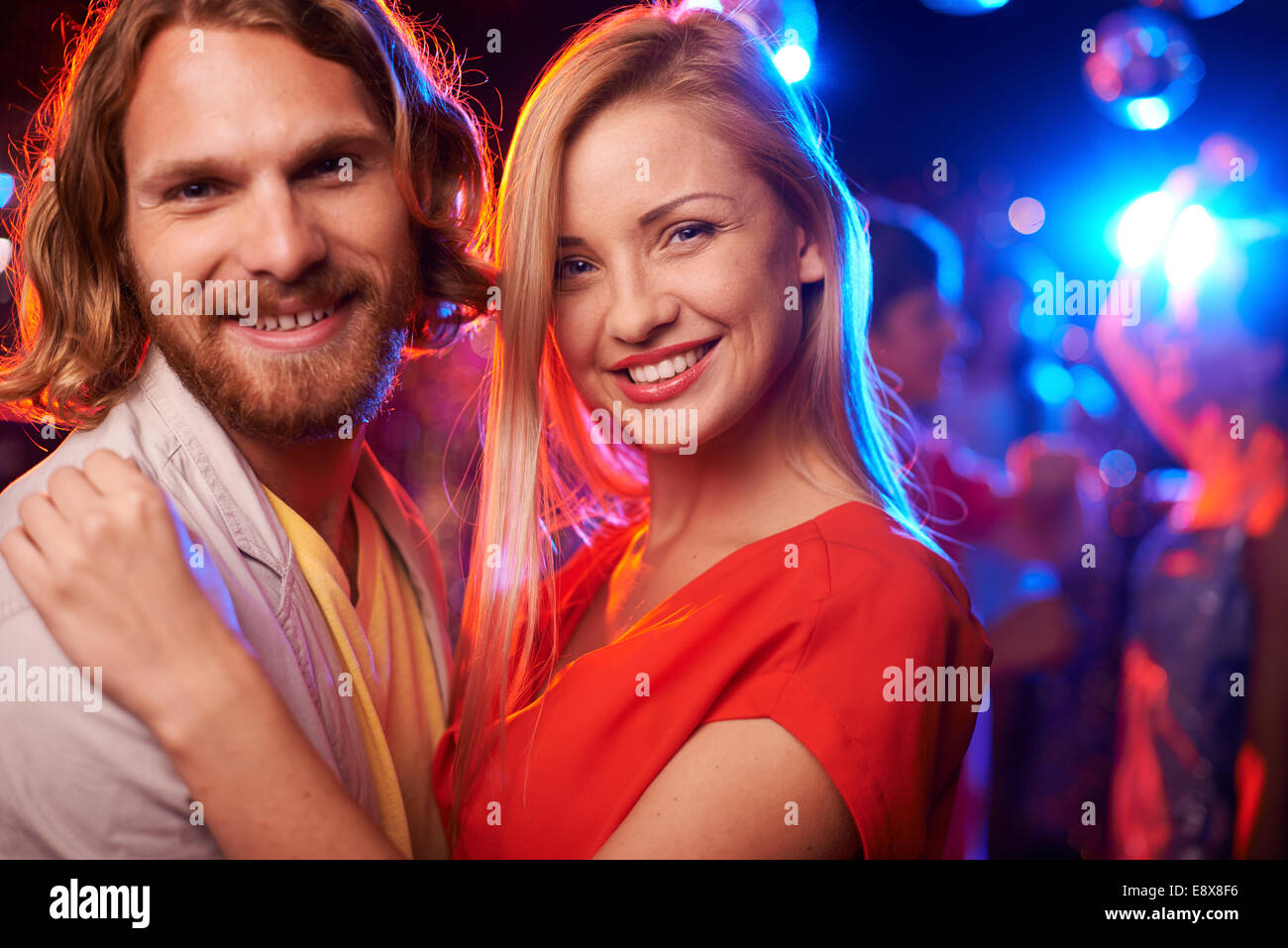 Happy beautiful couple embracing at party Stock Photo - Alamy