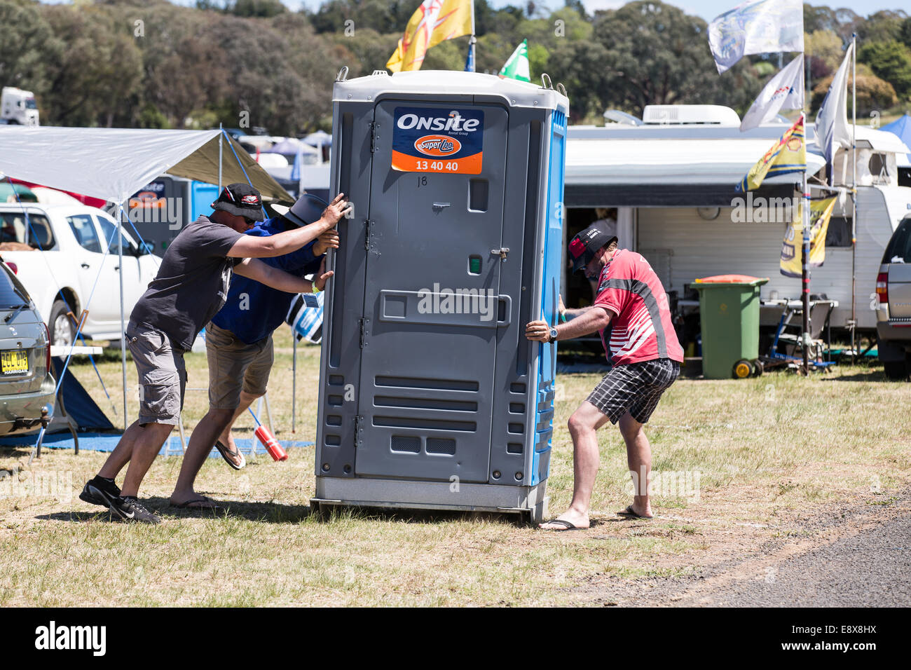Some men moving a portable toilet Stock Photo - Alamy