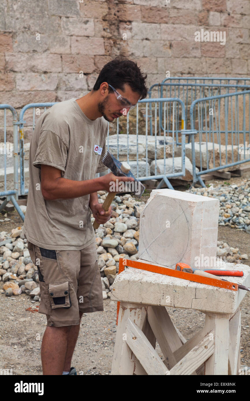 Mason forming a circular block for the renovation of Fort Saint-Nicolas ...