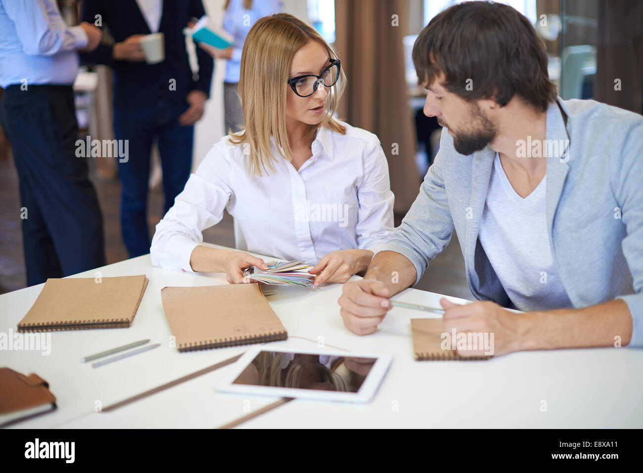 Male and female designers choosing color from palette in office Stock ...