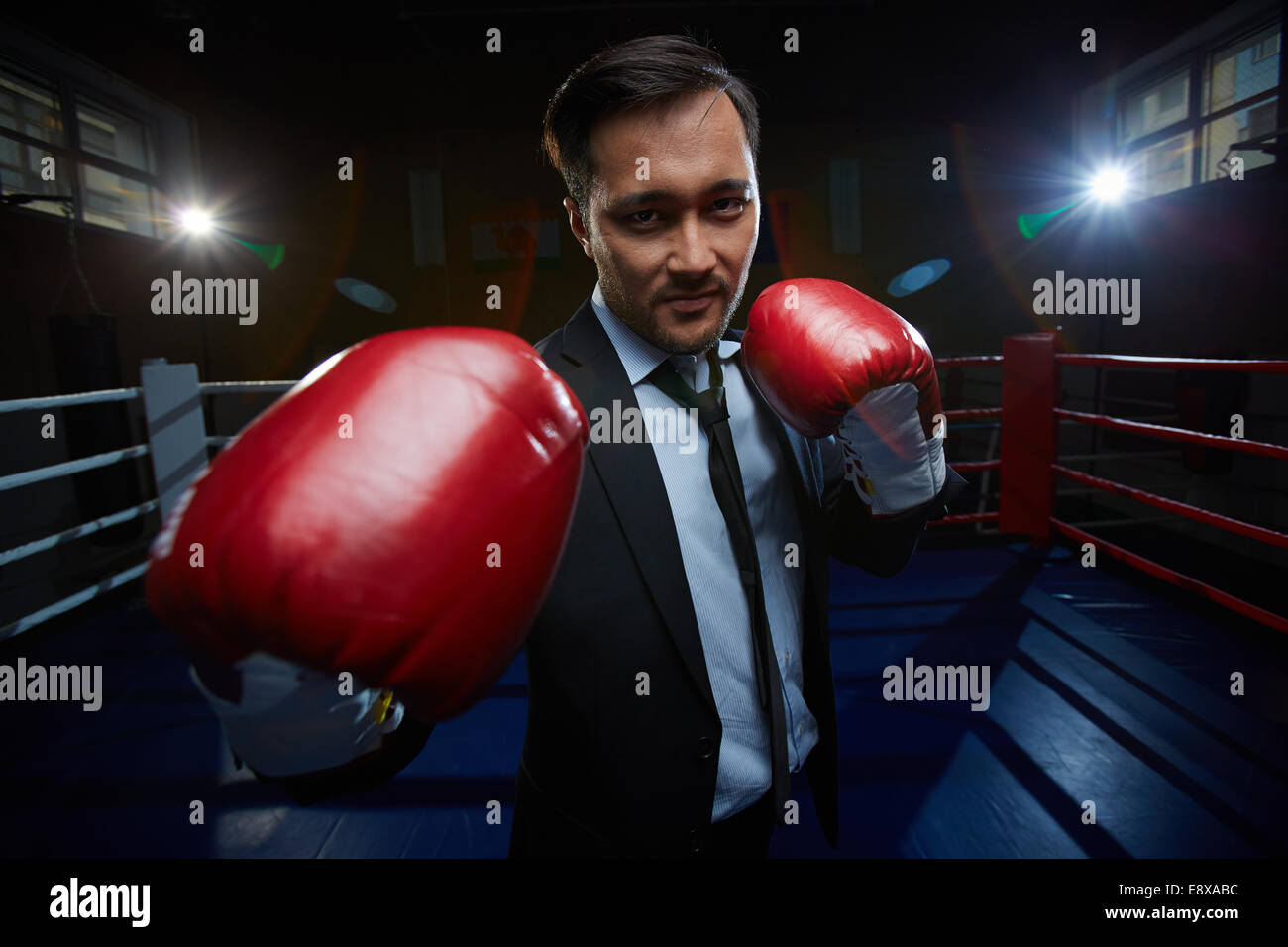 Strong and confident businessmen in suit and boxing gloves looking at ...