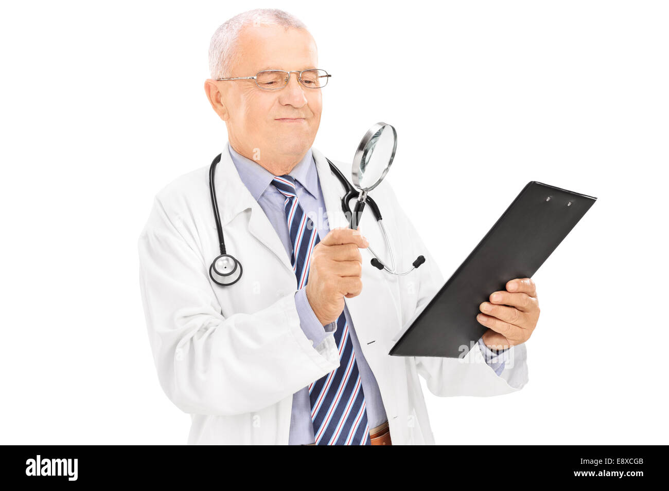 Mature doctor examining a document through a magnifying glass isolated ...