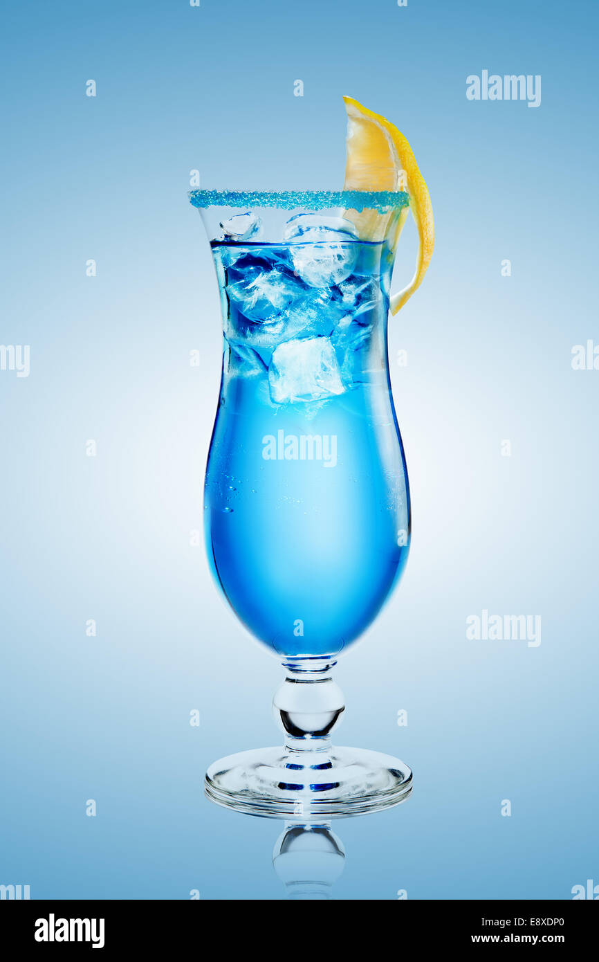 alcoholic cocktail Blue Lagoon with ice on blue background. The edge of ...