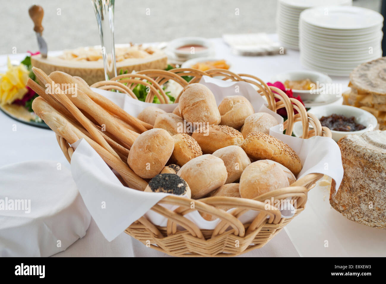 buffet table with basket of bread in foreground Stock Photo - Alamy