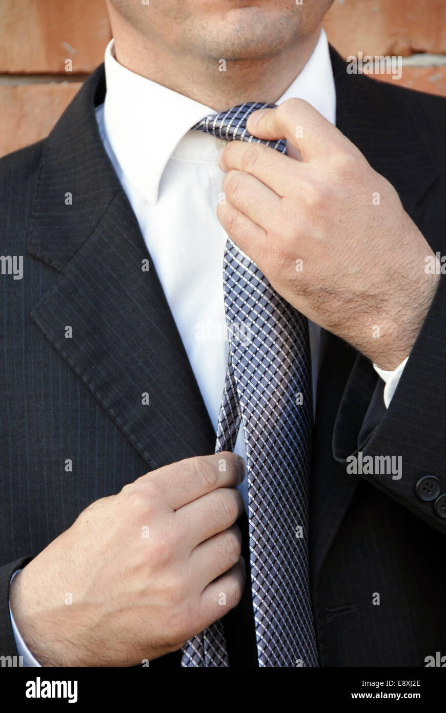 Businessman adjusting necktie Stock Photo - Alamy