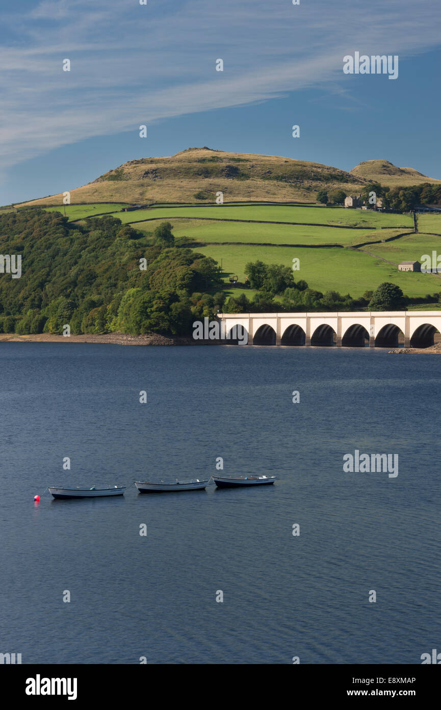 Blue summer sky over water of Ladybower Reservoir, boats moored, arches ...