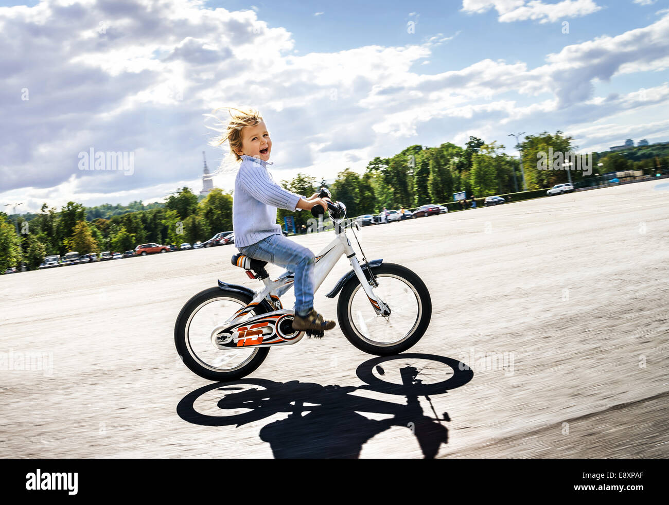 Cute little girl riding fast by bicycle in public park Stock Photo - Alamy