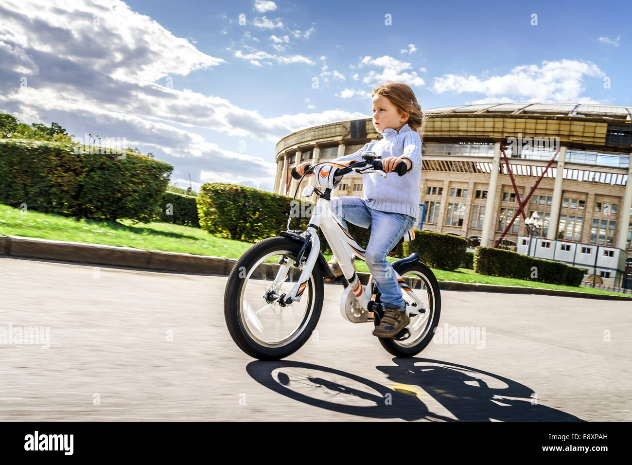 Cute little girl riding fast by bicycle in public park Stock Photo - Alamy