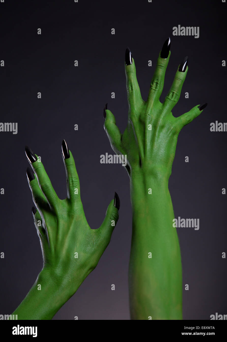 Green monster hands with black nails stretching up, real body-art ...
