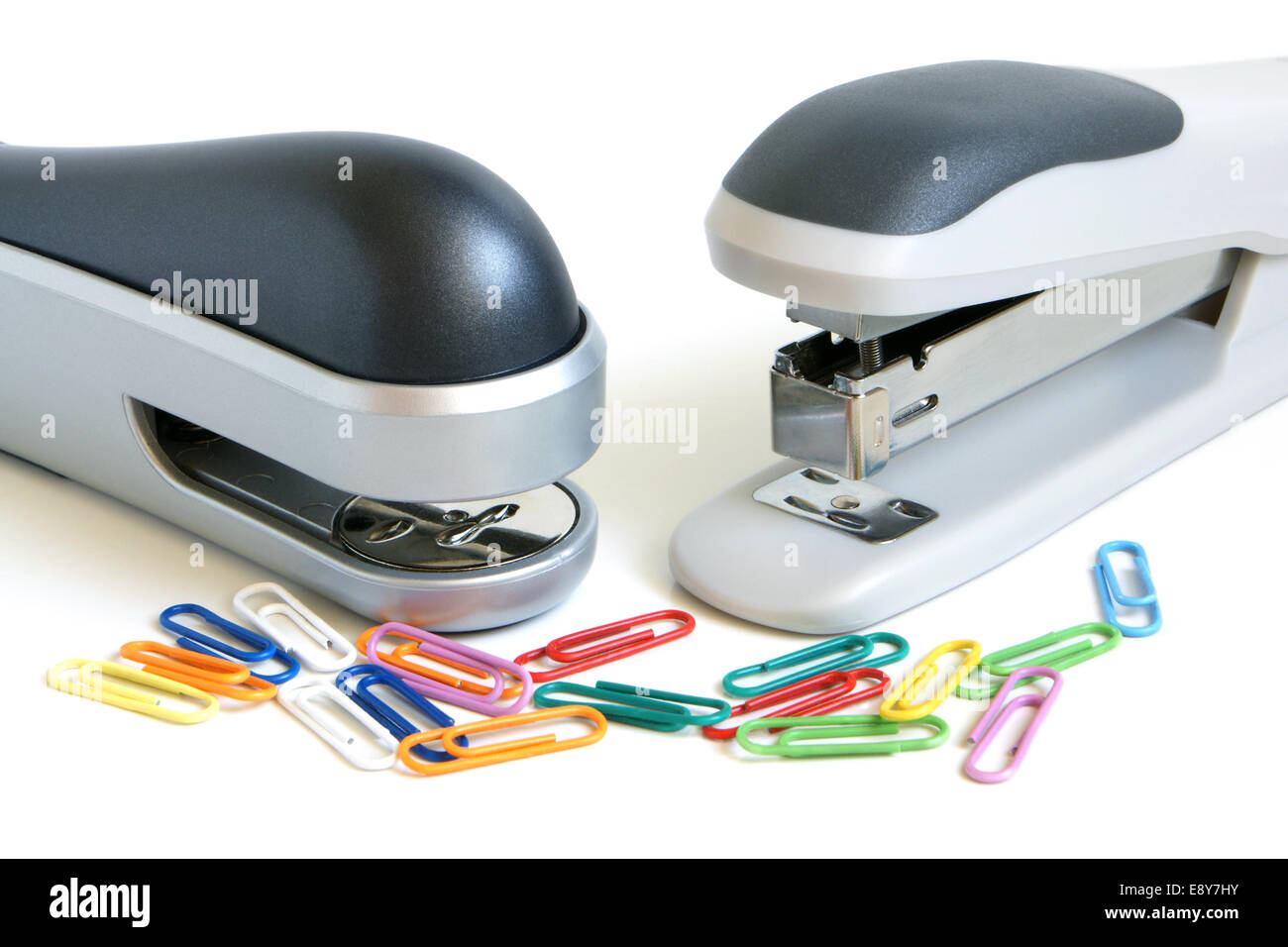 Two staplers and multicolored paper clips Stock Photo - Alamy