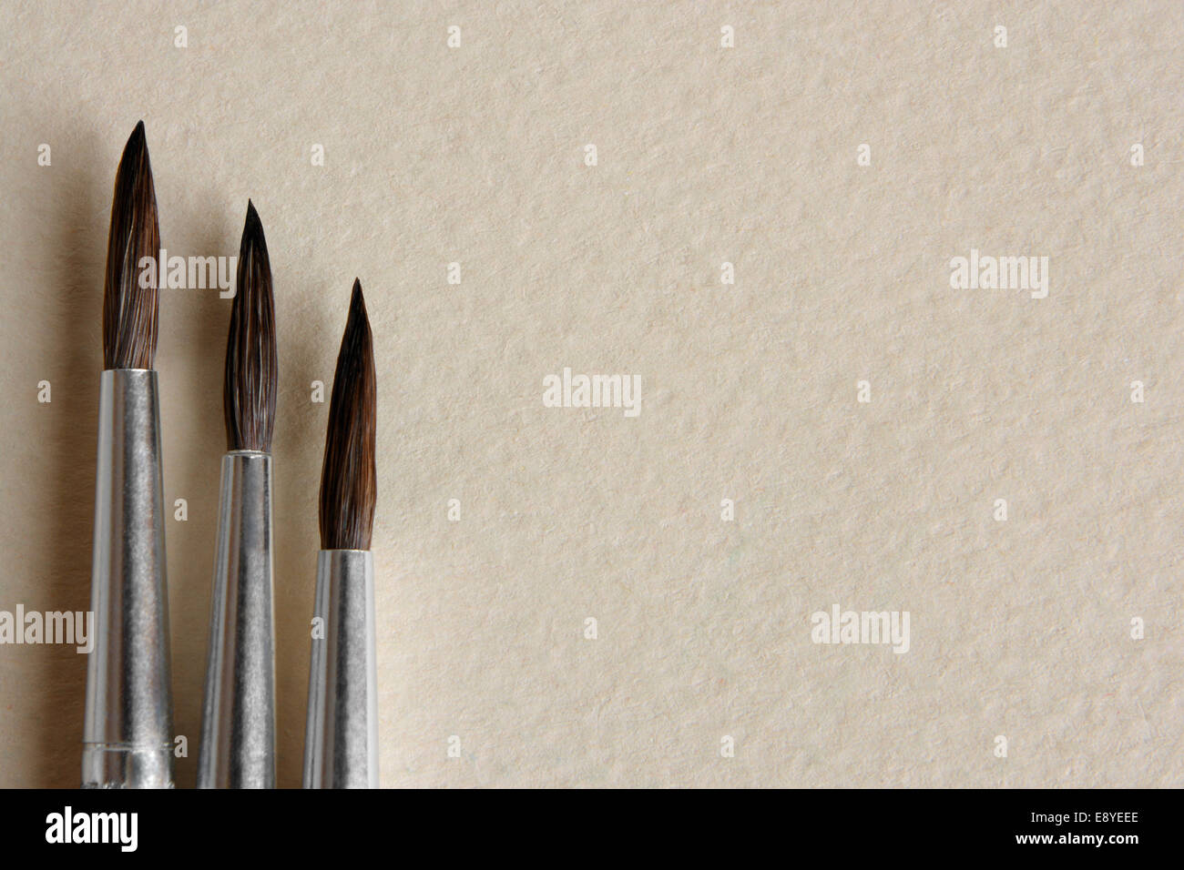 Paint brushes on papers background Stock Photo - Alamy