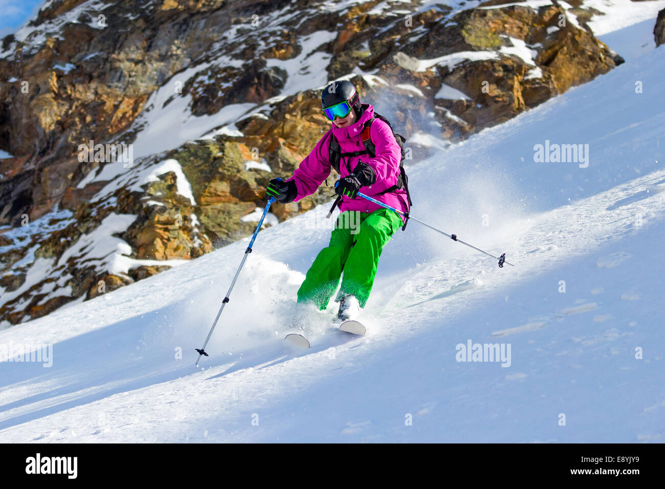 Skier at the turn on mountain steep slope off piste in soft snow on a ...