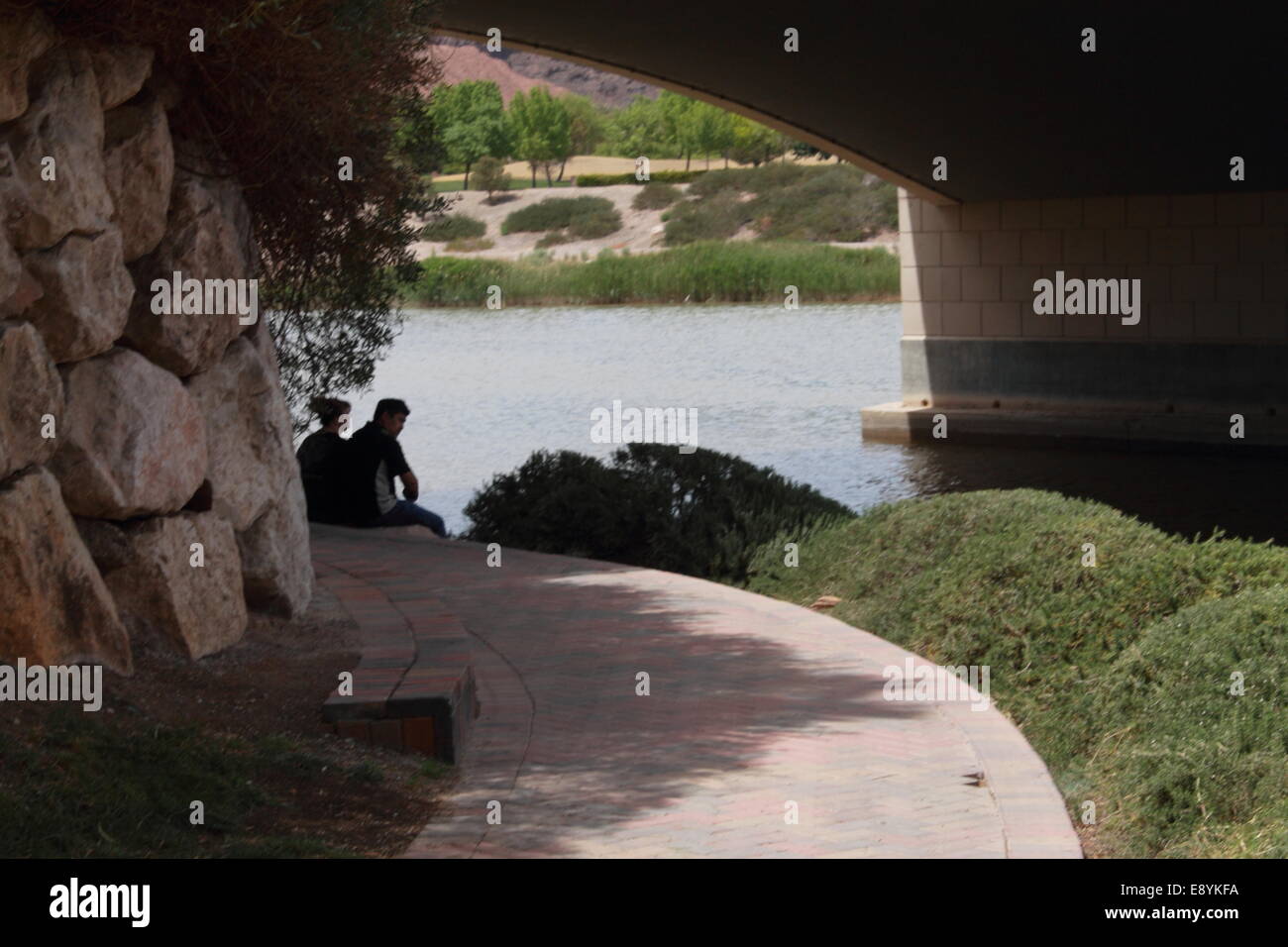 Two people relaxing under a bridge Stock Photo - Alamy